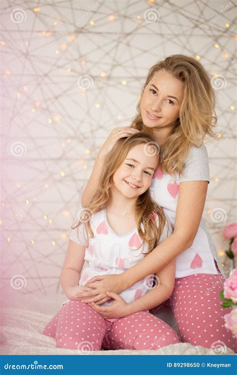 Retrato Feliz De La Familia Madre E Hija Que Abrazan En Cama Y Que Miran La Cámara En Pijamas