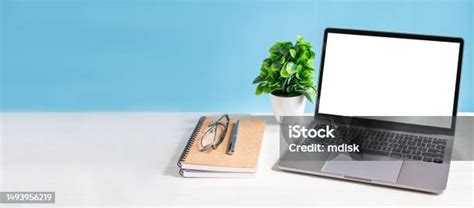 사무실의 나무 탁자 위에 있는 빈 하얀 화면 노트북 기술 노트북 인터넷 노트북 컴퓨터 네트워크를 사용하는 작업 개념 디자인을 위한 왼쪽 공간 복사 클로즈업 파란색 배경
