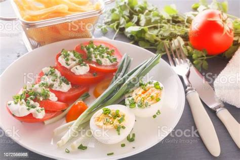 반 삶은 계란 토마토 녹색 양파와 회색 나무 테이블에 흰 접시에 야채와 함께 뿌 렸 다 0명에 대한 스톡 사진 및 기타 이미지