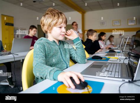 Blond Boy Learning Computer Coding Through Laptop In Classroom Stock