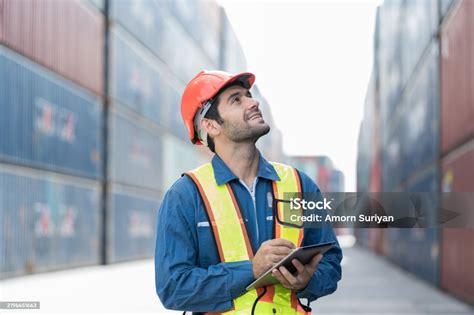 남성 작업자는 컨테이너 화물 현장에서 디지털 태블릿으로 작업하고 컨테이너 상자를 적재하고 상품을 적재하고 컨테이너를 점검하고 컨테이너를 선적합니다 화물 물류 및 운송 개념