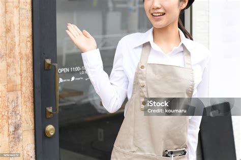 한 젊은 아시아 여성이 미소를 지으며 식당에서 길을 안내하고 있다 앞치마에 대한 스톡 사진 및 기타 이미지 앞치마 일본