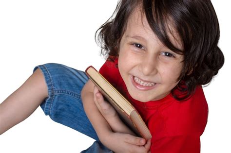 Retrato De Un Lindo Niño Sonriente Feliz Con Un Libro En La Mano Foto
