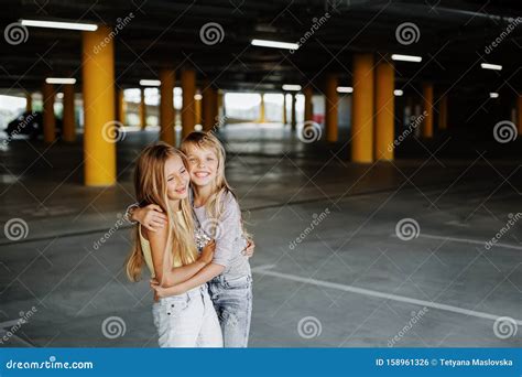 Two Beautiful Girls Having Fun And Playing In The Parking Lot Stock