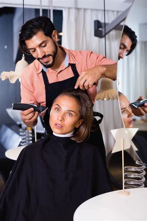 Portrait Of Smiling Man Hairdresser Cutting Woman S Hair In Salon Stock