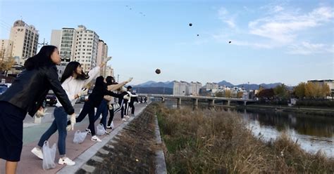 청소년들이 강변에 유용미생물 흙공 던져