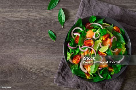 신선한 연어 샐러드와 토마토 시금치 양상추 어두운 배경에 검은 그릇에 바질 양파 위에서 최고 전망 건강한 맛있는 음식 수제 컨셉