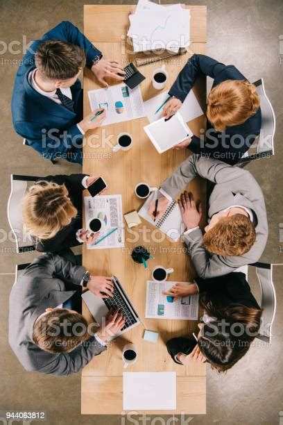 디지털 장치 커피 컵과 문서 테이블에서 논의 하는 비즈니스맨의 오버 헤드 보기 기업 문화에 대한 스톡 사진 및 기타 이미지