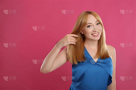 美丽的年轻女子金发在粉红色背景