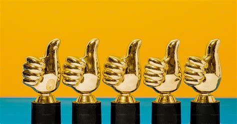 파란색과 노란색 배경에 황금색과 검은색 트로피가 한 줄로 늘어서 있습니다 사진 Unsplash의 격려 이미지