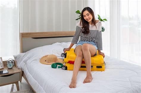 행복한 젊은 아시아 여성 포장 닫으려고 그리고 짐에 앉아 미소 여름 방학 여행 여행을위한 가방을 준비하는 소녀 카메라를보고 20 29세에 대한 스톡 사진 및 기타 이미지