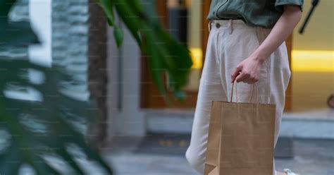 카페에서 걸어 나오는 종이 쇼핑백에 테이크 아웃 주문을 들고 아시아 여성 고객에게 테이크 아웃 주문을 준비하는 커피 숍 직원 중소 기업 소유자 식당 기업가와 도시 생활