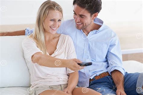 Happy Couple Relax And Watching Tv On Sofa For Entertainment Holiday