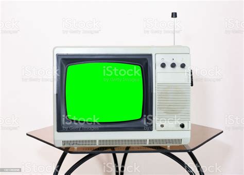 비디오와 이미지를 추가하기위한 녹색 화면이있는 복고풍 Tv는 빈티지 벽지의 배경에 대한 방에있는 의자에 서있습니다 0명에 대한