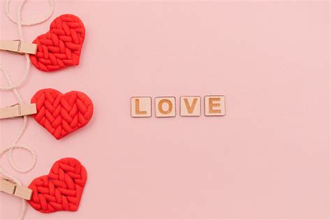 분홍색 배경에 매달려 있는 빨간 하트 배경에 사랑이라는 단어 발렌타인 데이 컨셉 플랫 레이 상단 보기 0명에 대한 스톡 사진 및