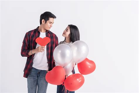아름 다운 젊은 가정에서 부부 즐길 축 하 세인트 발렌타인의 날에 함께 시간을 보내고 풍선 행복 선물 종이 심장 빨간색과 흰색을