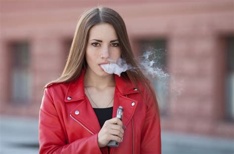 Garota Fuma Um Cigarro E Solta Fumaça Em Uma Boate Foto Premium