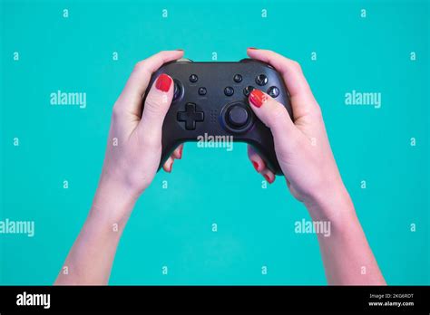 POV Of Female Hands Gaming With Video Game Controller Gamepad Isolated On A Blue Background