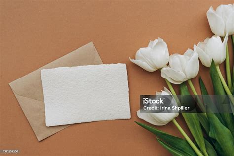 흰색 튤립과 빈 비즈니스 인사말 카드 갈색 배경에 초대 모형이있는 정물 장면 3월에 대한 스톡 사진 및 기타 이미지 3월