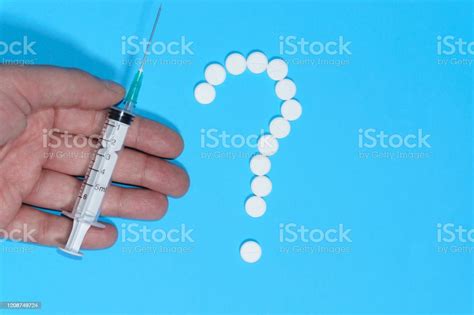 파란색 배경에 손에 주사기 텍스트에 대한 장소입니다 공간을 복사합니다 약을 복용의 개념 알 약과 주사를 선택 개념에 대한 스톡