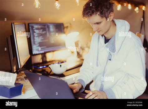 A Man Sitting At A Desk Working From Home On His Computer It Specialist Programmer Writing Code