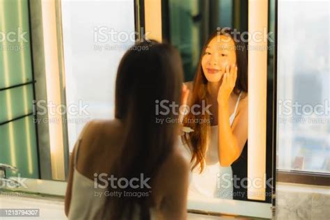 초상화 아름다운 젊은 아시아 의 여자 적용 크림 에 그녀의 얼굴 과 얼굴 에 욕실 깨끗한에 대한 스톡 사진 및 기타 이미지