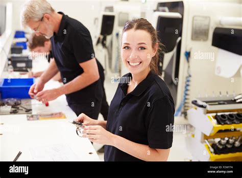 Workers In Engineering Factory Checking Component Quality Stock Photo