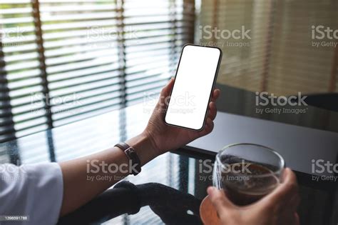 테이블 위에 노트북으로 커피를 마시면서 빈 데스크톱 화면으로 휴대폰을 들고 있는 여성의 모형 이미지 35 39세에 대한 스톡