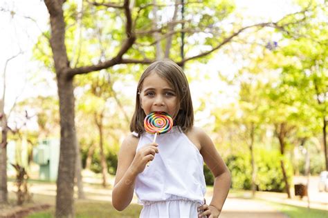 Menina Loira Chupando Pirulito Em Um Parque Ao Ar Download Designi