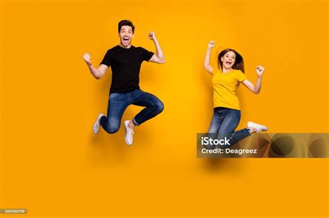 스포티 한 남자와 여자 커플 점프 인생의 높은 활성 방법 첫 번째 승리 장소 대회를 축 하 캐주얼 청바지 티셔츠 고립 된 노란색 색상 배경의 전체 길이 사진 점프에 대한