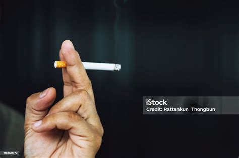 손에 담배를 피우는 남자를 들고 담배 연기 확산 어두운 검은 색 배경 직접 작업할 수 있습니다 금연 표시에 대한 스톡 사진 및