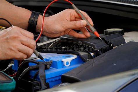 Technician Checks The Battery Using A Voltmeter Capacity Tester Auto