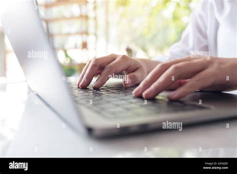 Closeup Image Of Hands Working And Typing On Laptop Keyboard On Table With Blur Nature
