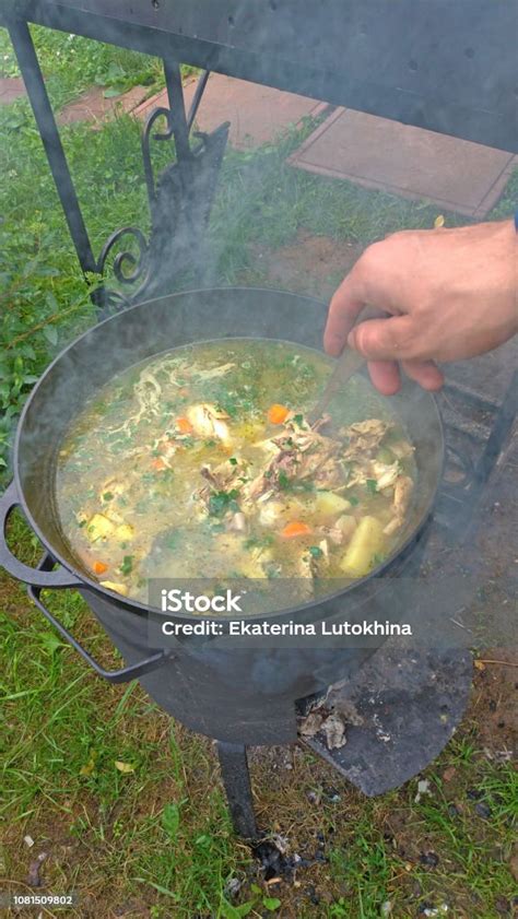 맛 있는 치킨 수프는 검은 무 쇠 냄비에 사격에 요리는 남자의 손 국자와 수프를 시도합니다 길거리 음식 고기에 대한 스톡 사진 및 기타 이미지 Istock