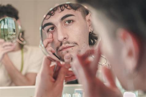 Young Man Examining His Face In Bathroom Mirror Exploring Identity And Diversity Stock Image