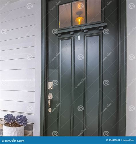 Square Home Facade With Glass Paned Front Door And Furniture On The
