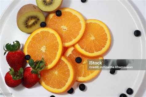 얇은 둥근 오렌지 조각과 딸기 키위 과일 블루베리가 하얀 접시에 얹어져 있습니다 감귤류 과일에 대한 스톡 사진 및 기타 이미지