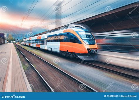 High Speed Orange Train In Motion On The Railway Station Stock Image