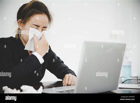 Sick Young Asian Business Woman Sitting Alone At Work Sneeze Holding
