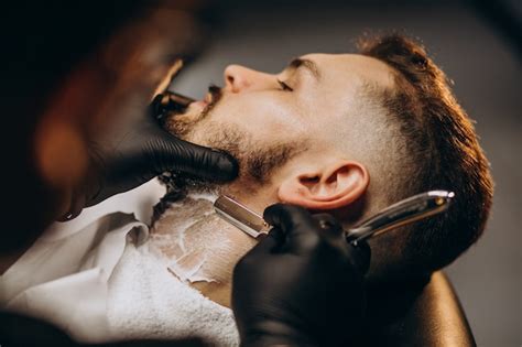 Bel Homme Coupe La Barbe Dans Un Salon De Coiffure Photo Gratuite