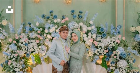 A Couple Posing For A Picture In Front Of A Floral Backdrop Photo