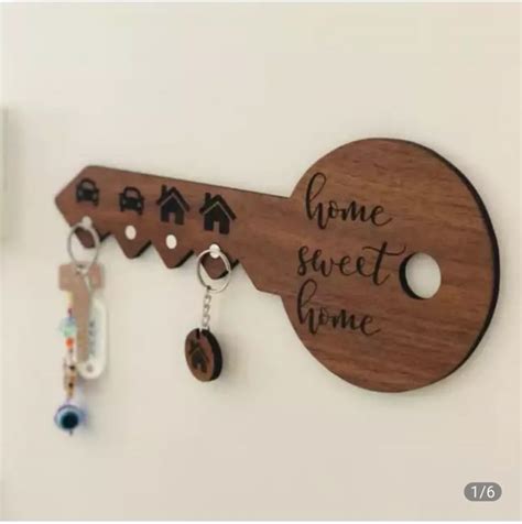 A Wooden Key Chain Hanging From The Side Of A Wall Next To A Light Switch