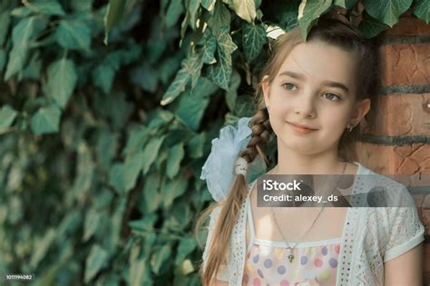 Kleines Mädchen Mit Geflochtenen Haaren Und Einem Bogen Nachdenklich Outdoorsommerporträt