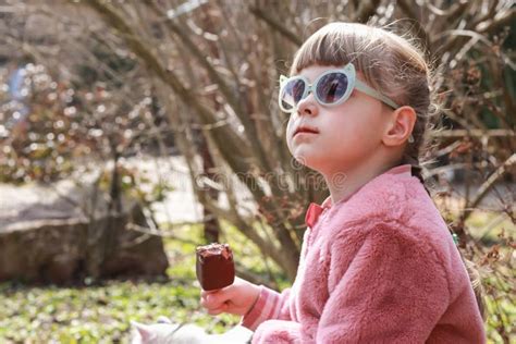 Menina Com Rabo De Sol Tomando Sorvete De Chocolate Em Um Banco De
