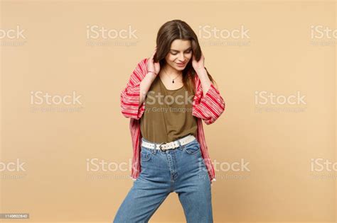 캐주얼에 예쁜 부드러운 젊은 여자의 초상화 스튜디오에서 파스텔 베이 지 배경에 고립 된 아래로 보이는 머리에 손을 퍼 팅