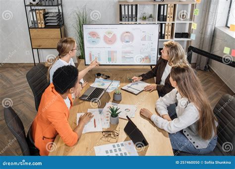 Group Of Multiracial Female Financial Analysts Sitting Together At