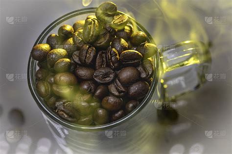 将咖啡豆放在带有淡黄色烟雾的玻璃杯中
