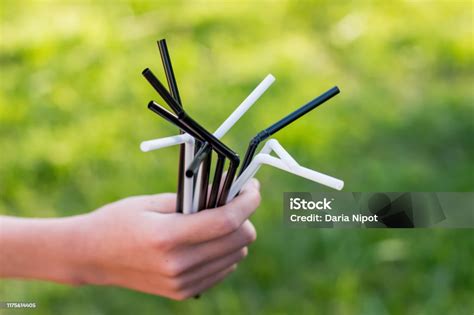 녹색 잔디 배경에 플라스틱 빨대의 꽃다발을 들고 손 플라스틱 오염 환경 폐기물 플라스틱 빨대에 아니오라고 말하십시오 우리의 녹색 행성을 저장 개념에 대한 스톡 사진 및 기타