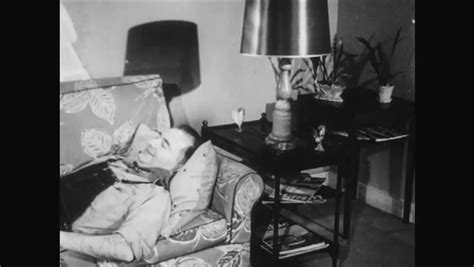 1950s UNITED STATES Man With Heat Stroke Lies On Sofa Lady Mops Man