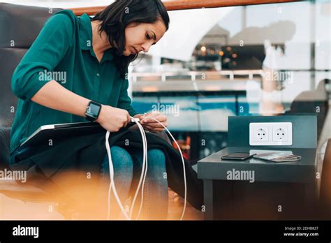 Mid Adult Businesswoman Plugging USB Cable Into Laptop At Airport Stock Photo Alamy